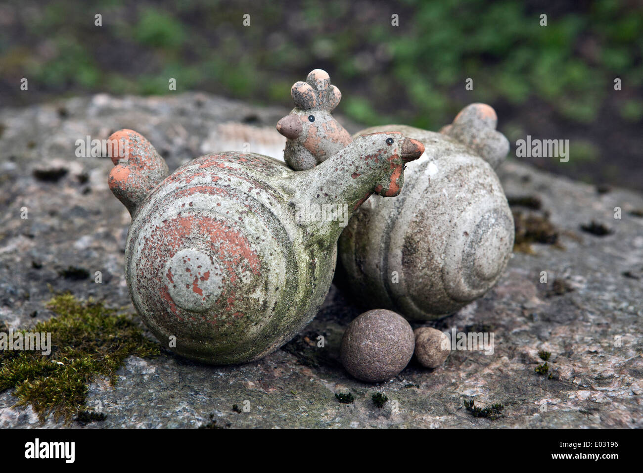 Easter icons- chicken and eggs placed on rock in yard Stock Photo - Alamy