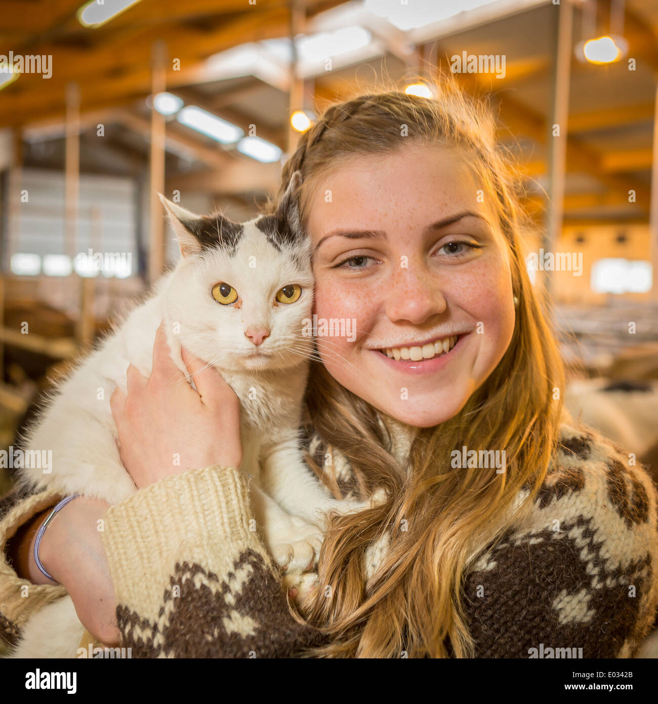 Teenage girl with a milk mustache holding her cat, family farm, Western ...