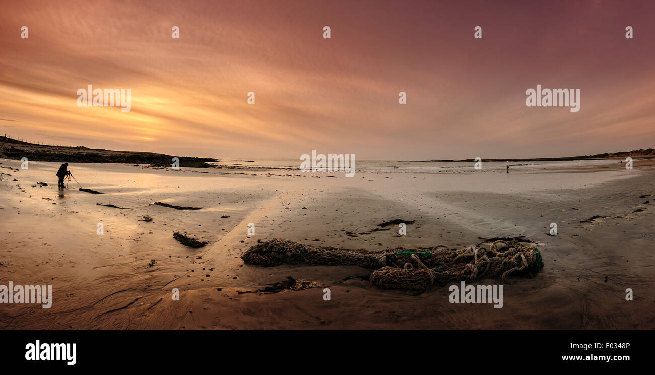 A photographer records the sunset on the beach at Balivanich, Benbecula ...