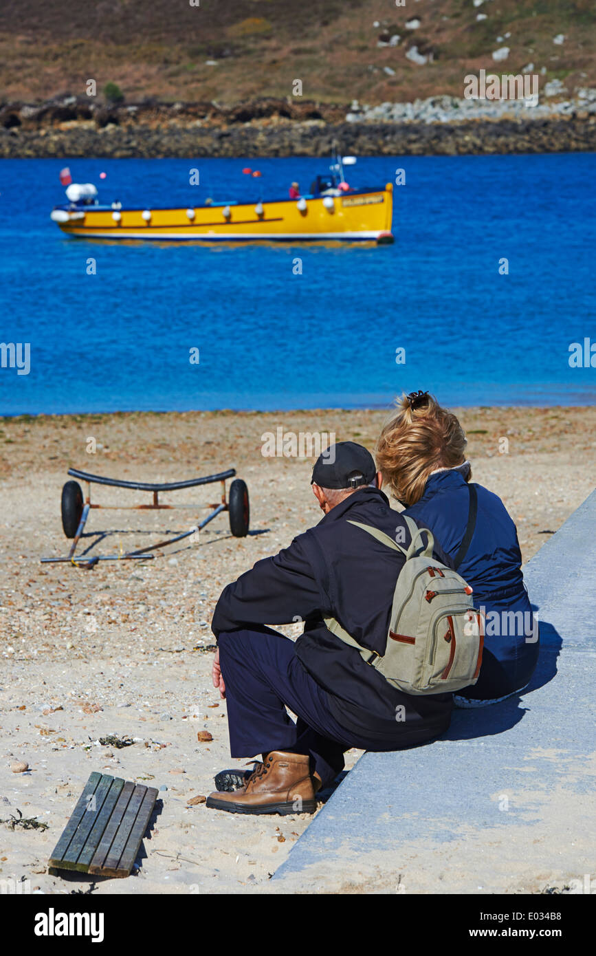 Couple sat waiting for the Golden Spray boat at Anneka’s Quay, Bryher ...