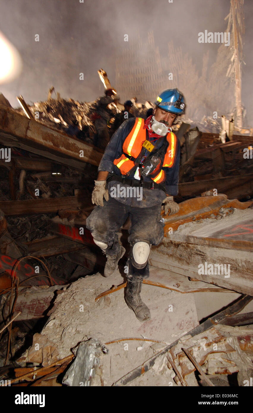 Urban Search and Rescue teams work to clear rubble from the wreckage of ...