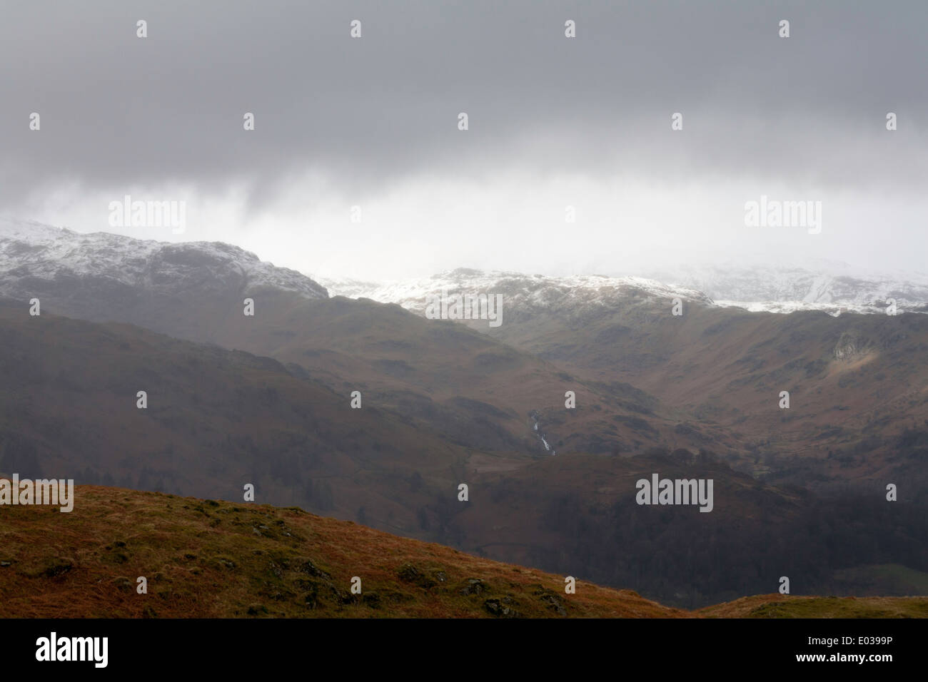 Storm clouds and snow over Wetherlam and The Old Man of Coniston from ...