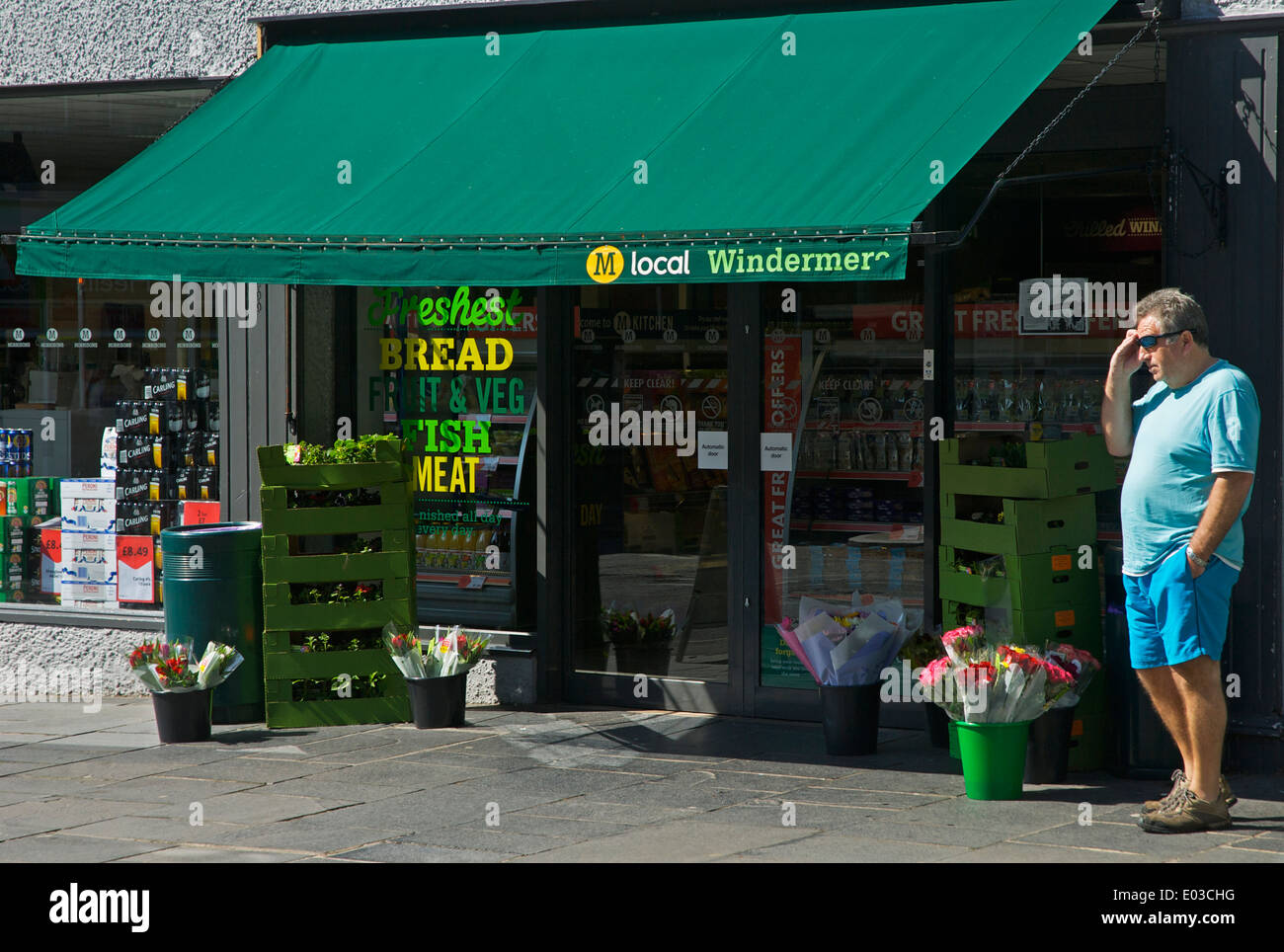 Man standing outside Morrisons M Local store in Windermere, Lake ...