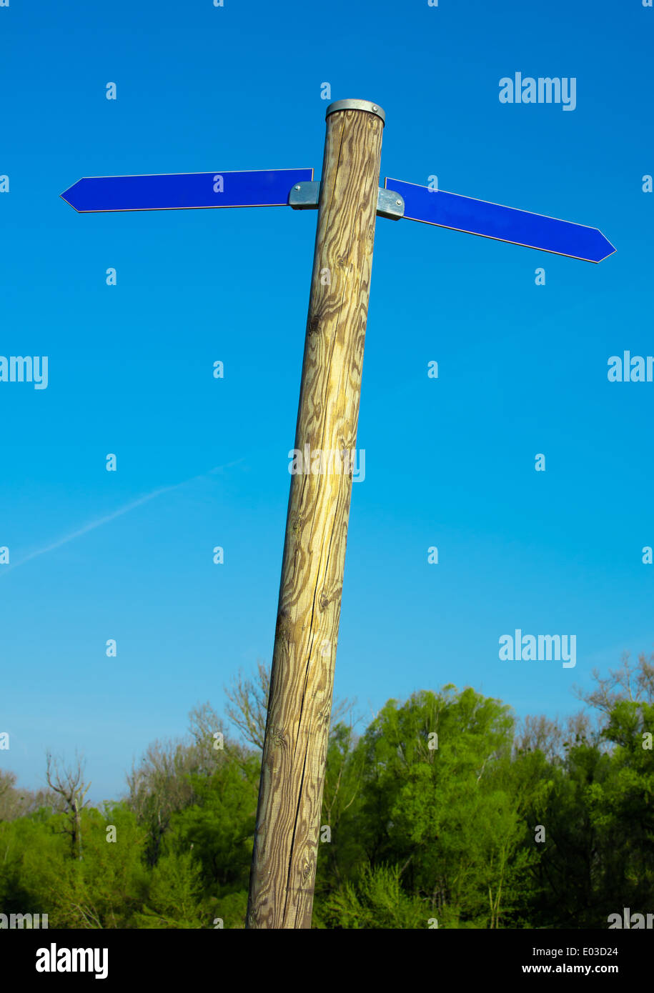 Wooden Pole With Blue Direction Arrows Stock Photo - Alamy