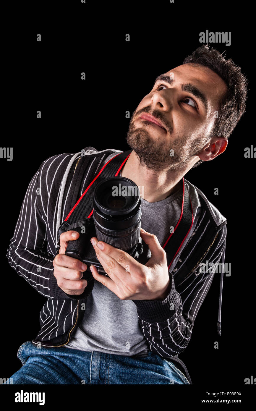 an handsome photographer with a dslr isolated on a black background ...