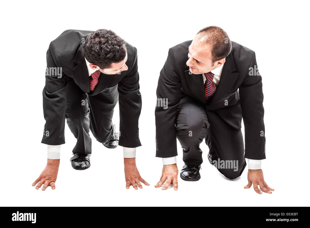 two competitive businessmen in starting position ready to run a race ...