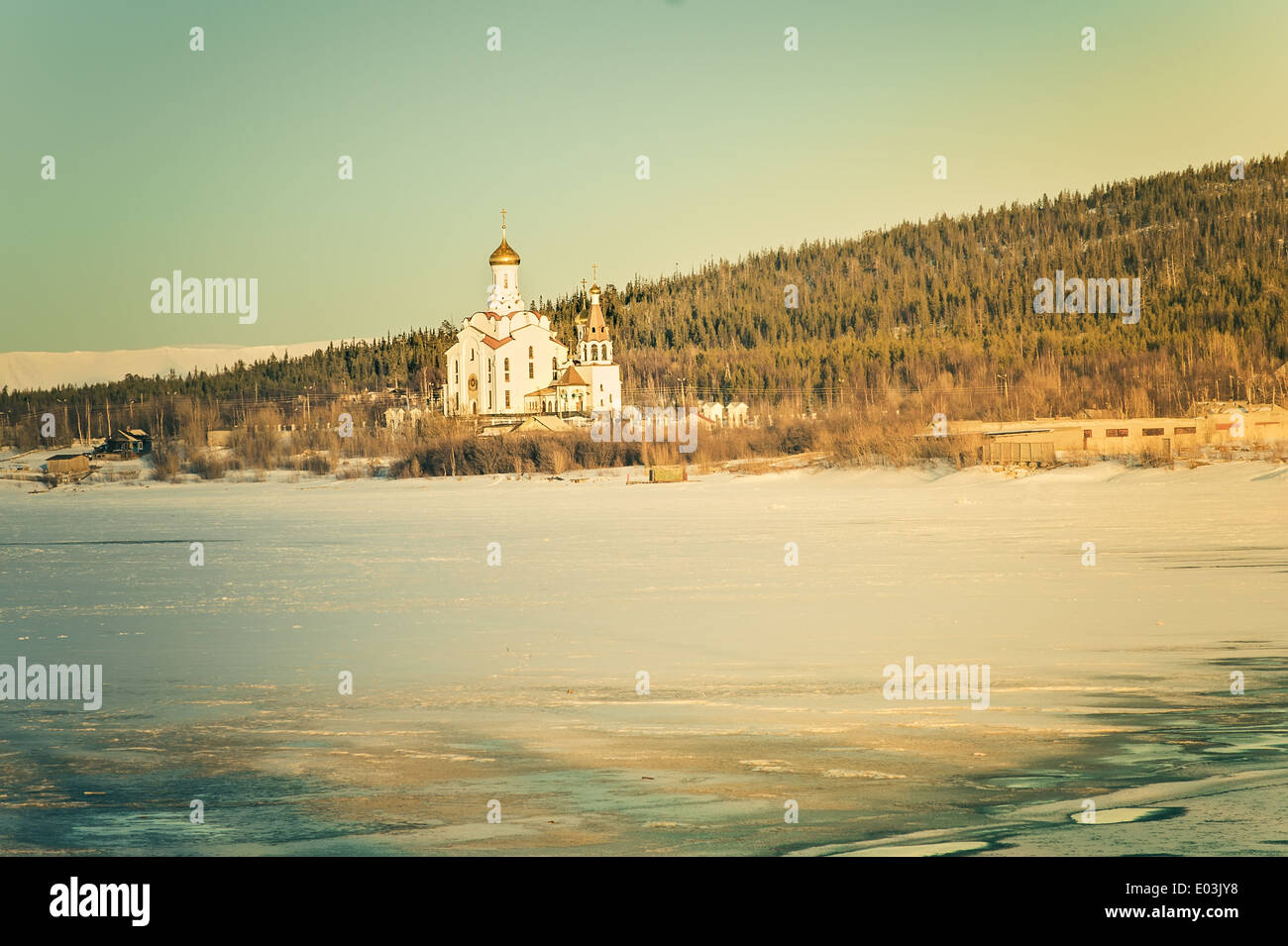 Christian Orthodox Church temple on icy lake with forest mountains on ...