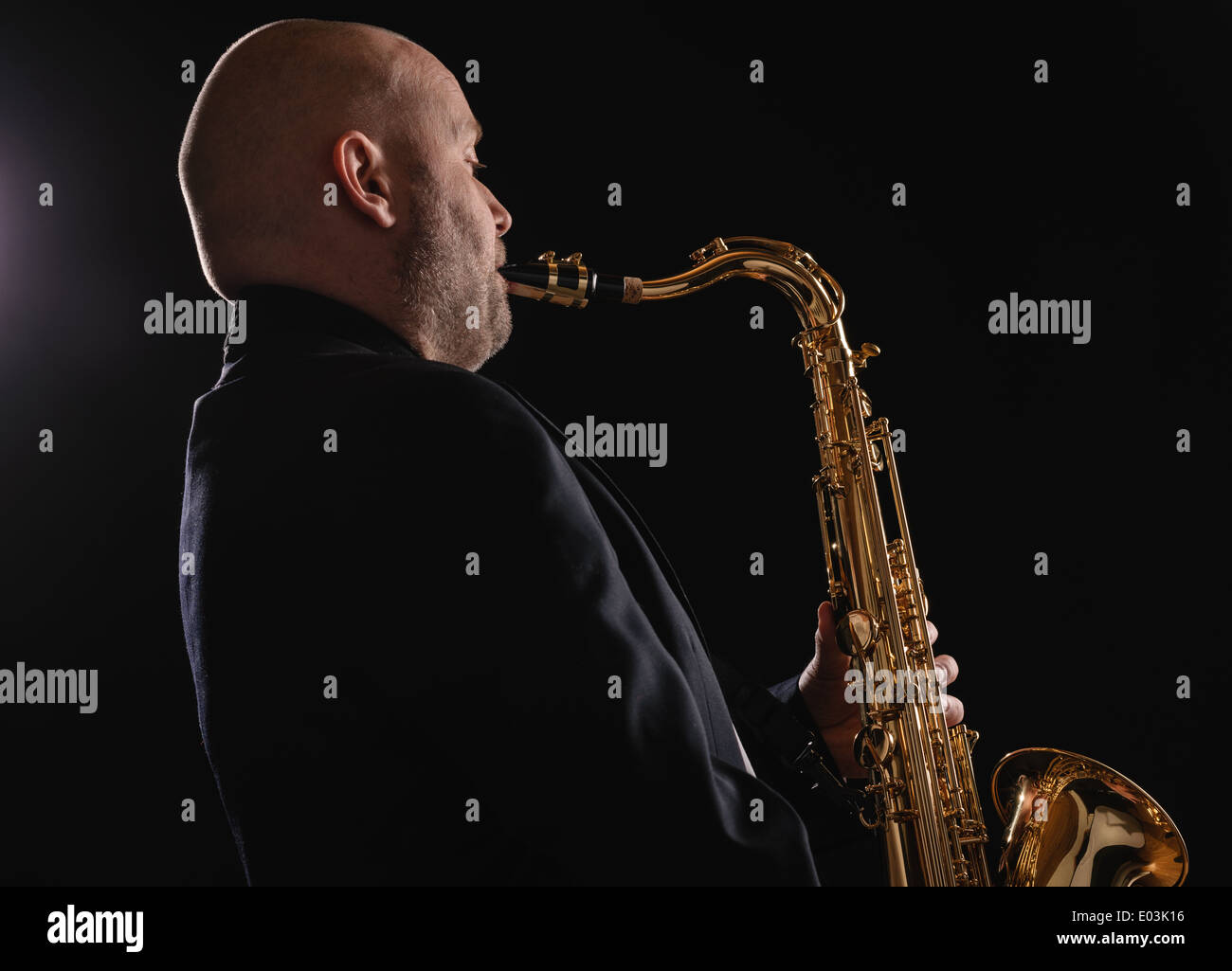 Adult musician playing tenor saxophone, dark background Stock Photo - Alamy