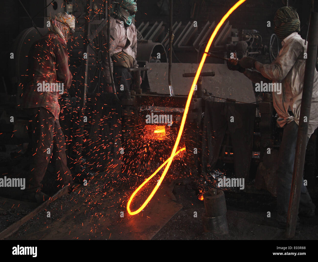 LAHORE, PAKISTAN, MAY 01: Pakistani blacksmiths work at an iron molding ...