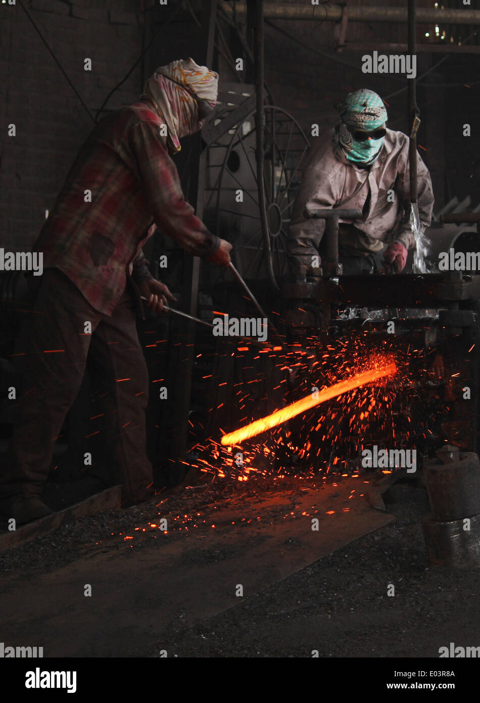 LAHORE, PAKISTAN, MAY 01: Pakistani blacksmiths work at an iron molding ...
