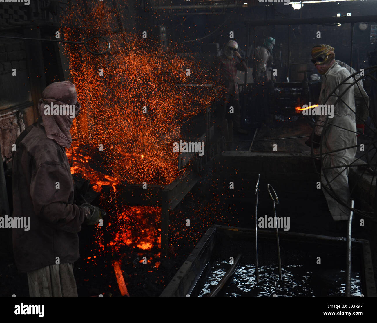 LAHORE, PAKISTAN, MAY 01: Pakistani blacksmiths work at an iron molding ...
