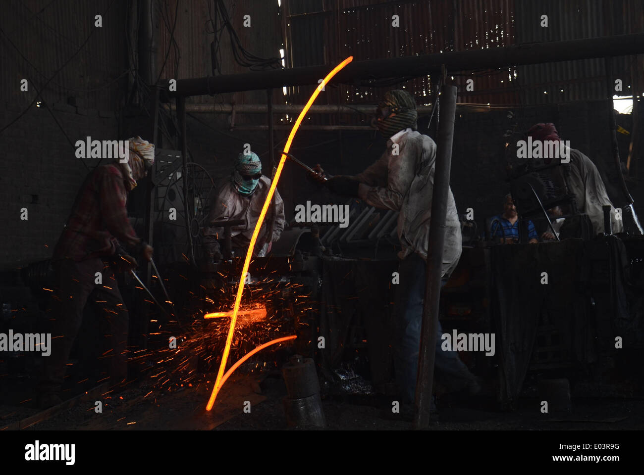 LAHORE, PAKISTAN, MAY 01: Pakistani blacksmiths work at an iron molding ...