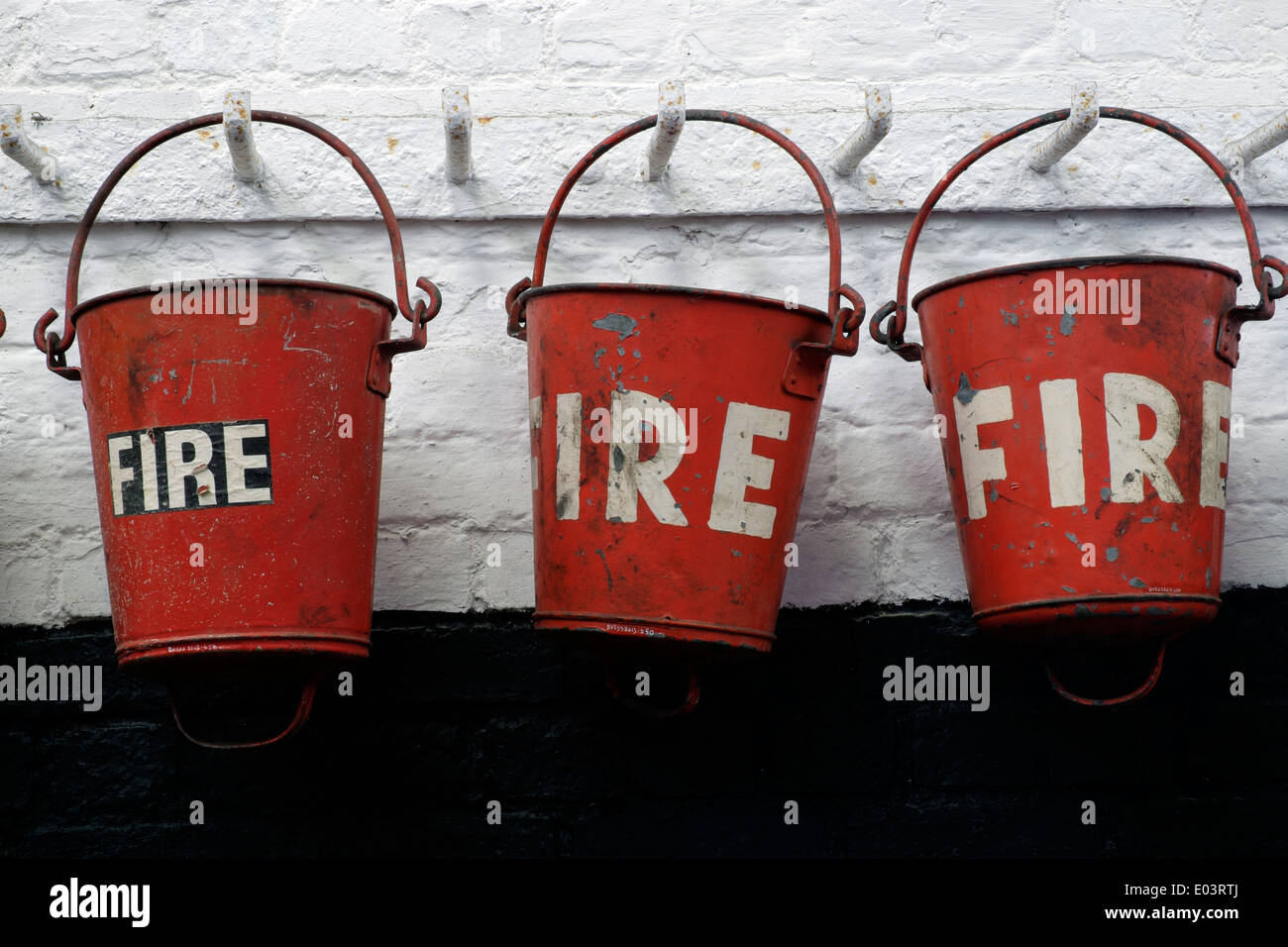 red fire buckets hanging on white wall Derbyshire England Stock Photo ...