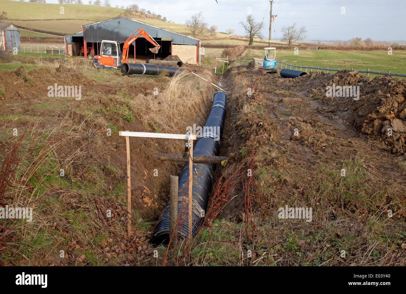 Kubota excavator Installing twinwall drainage pipes ditch UK Stock ...