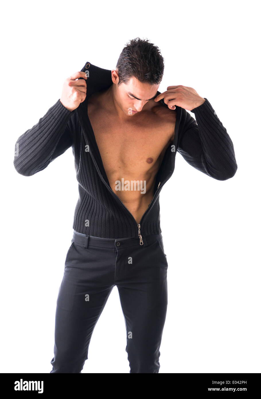 Confident, attractive young man with open sweater on muscular torso ...