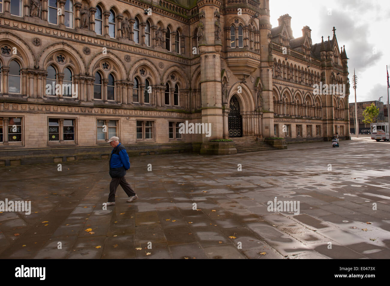 Man walking in quiet pedestrian area, across damp pavement of Centenary ...