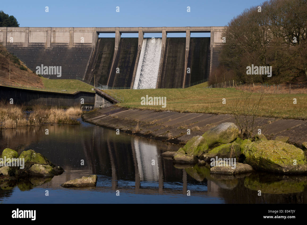 High, steep-sided, concrete dam at Thruscross Reservoir reflected in ...