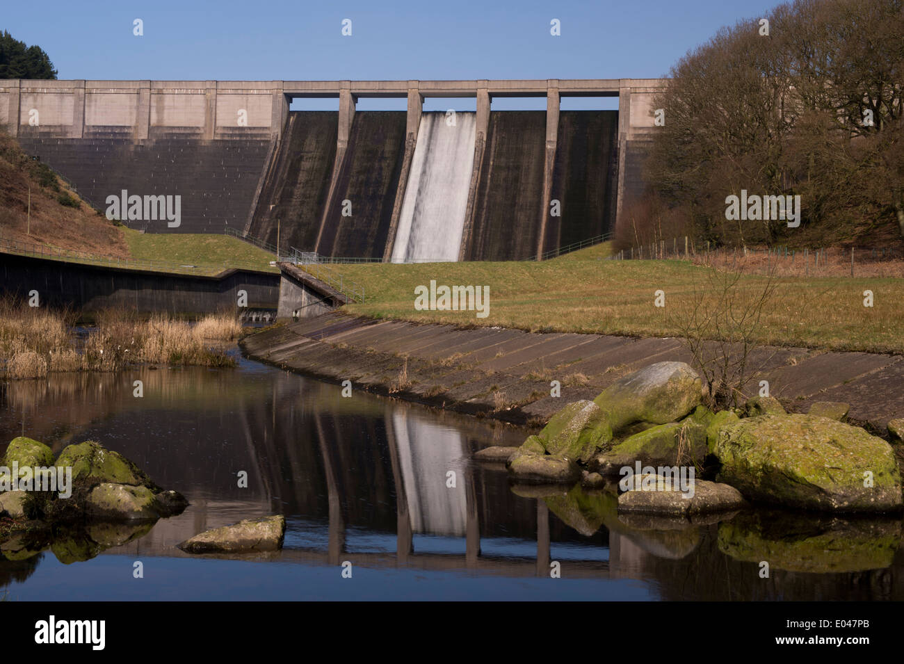 High, steep-sided, concrete dam at Thruscross Reservoir reflected in ...