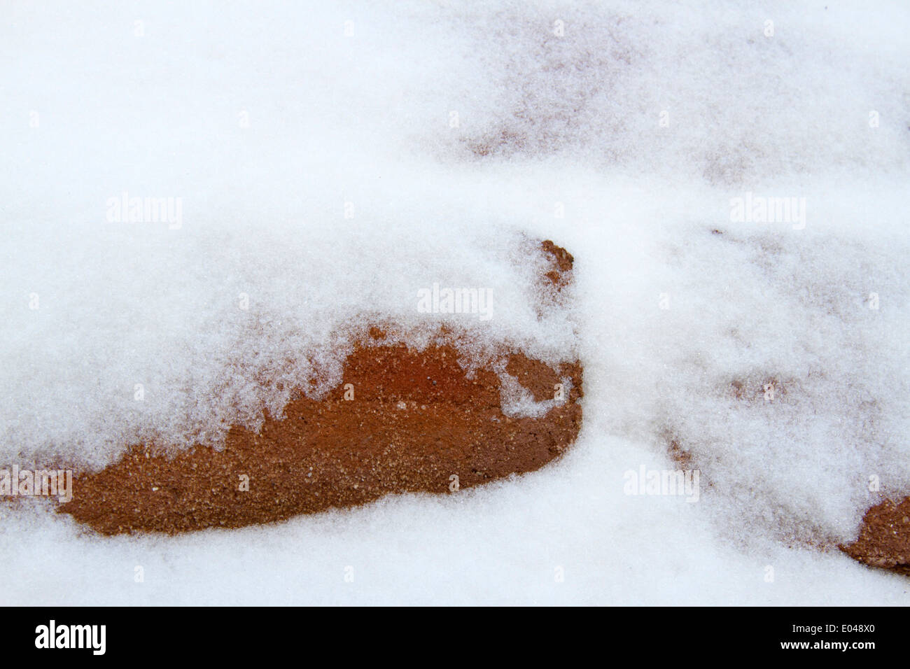 Texture and color created from snow covering a natural red brick wall ...