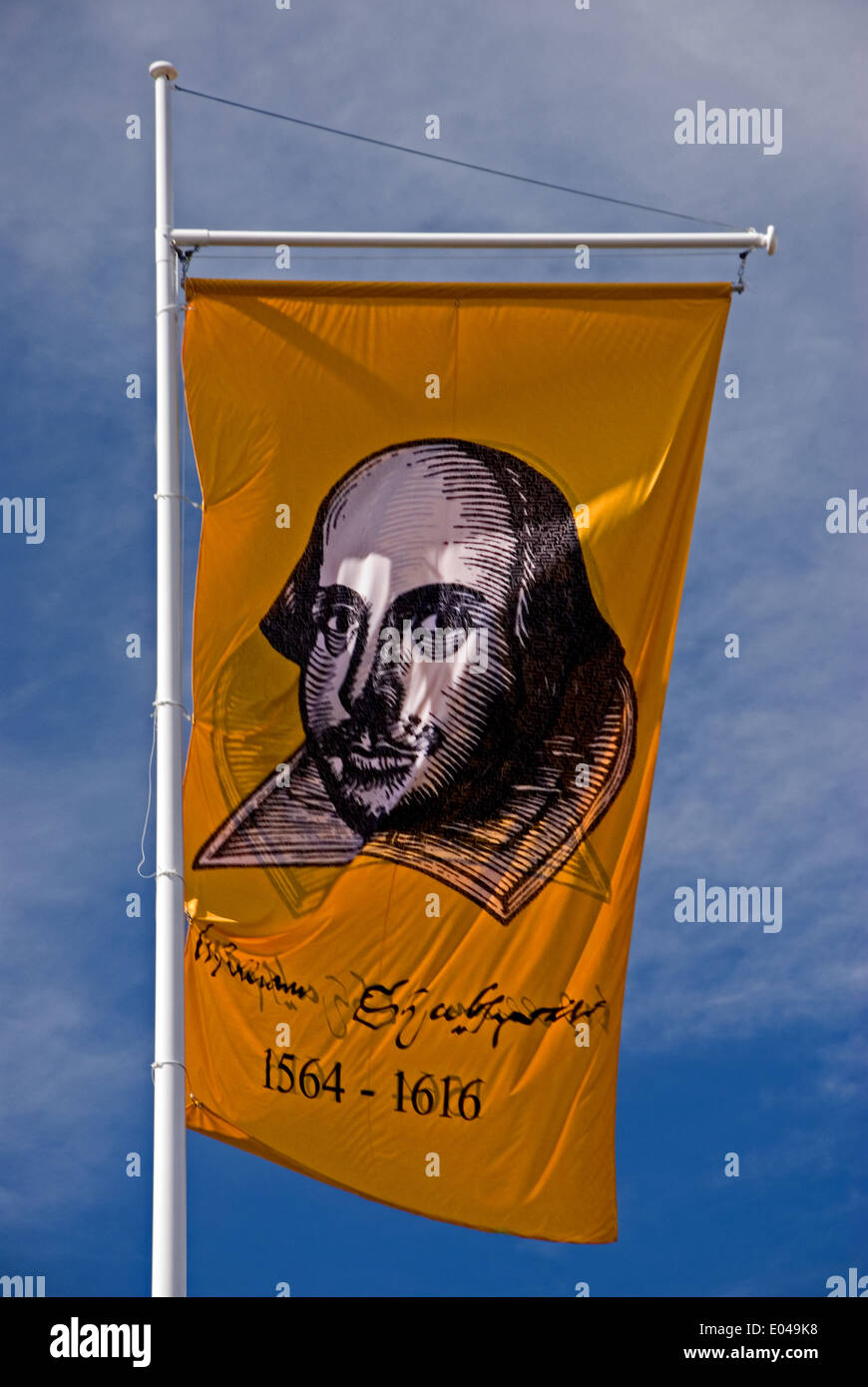 Face of William Shakespeare on a yellow flag against a blue sky as part ...