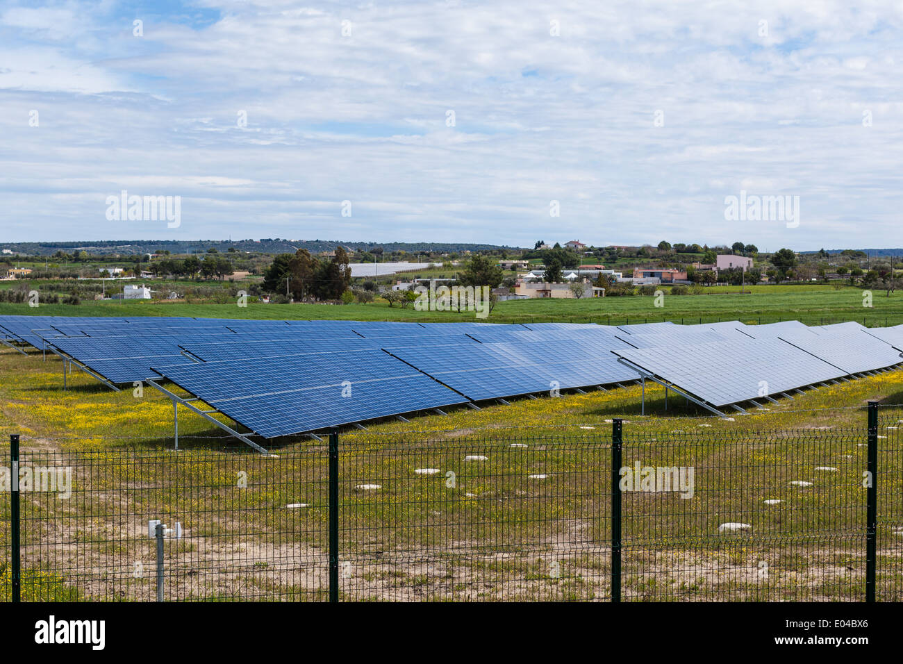 several solar panels in a field with green grass Stock Photo - Alamy