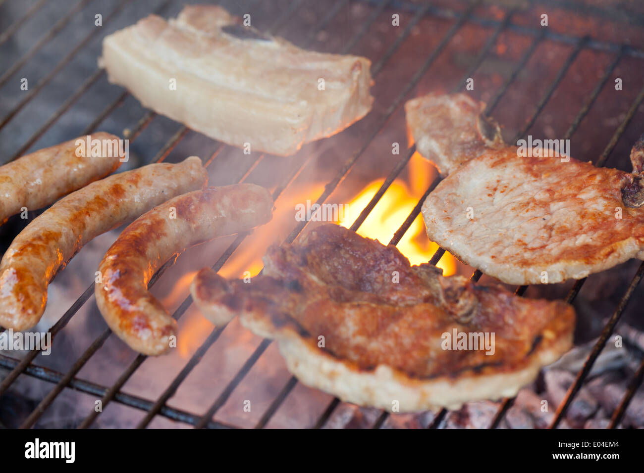 Several type of meats being cooked on a barbecue Stock Photo - Alamy
