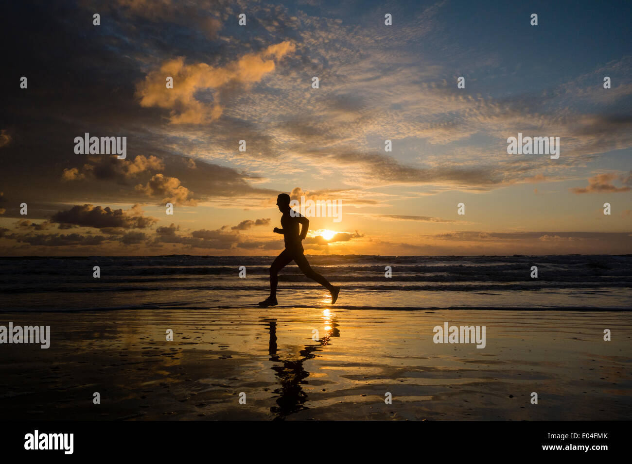 Man running on beach at sunrise. UK Stock Photo - Alamy