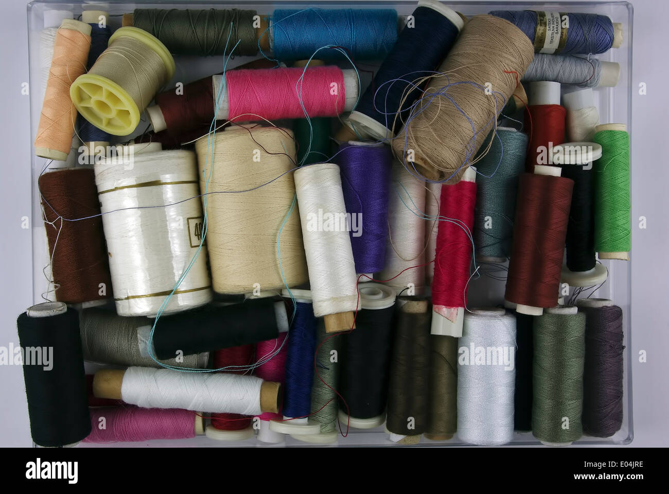 Sewing cotton in different colors, packed and unpacked, in plastic box ...