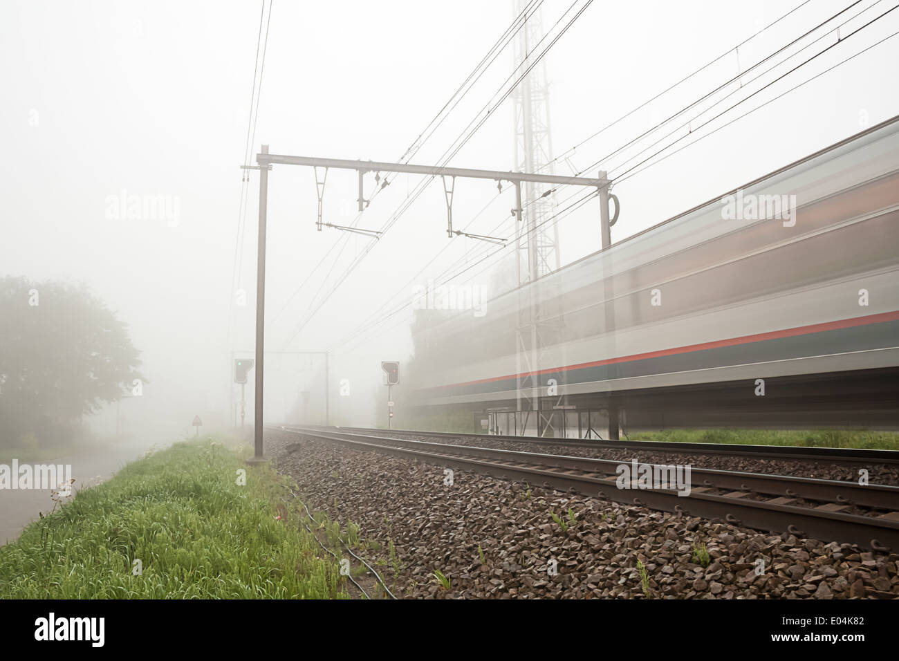 hangs a thick fog along the road and railway passing a train Stock ...