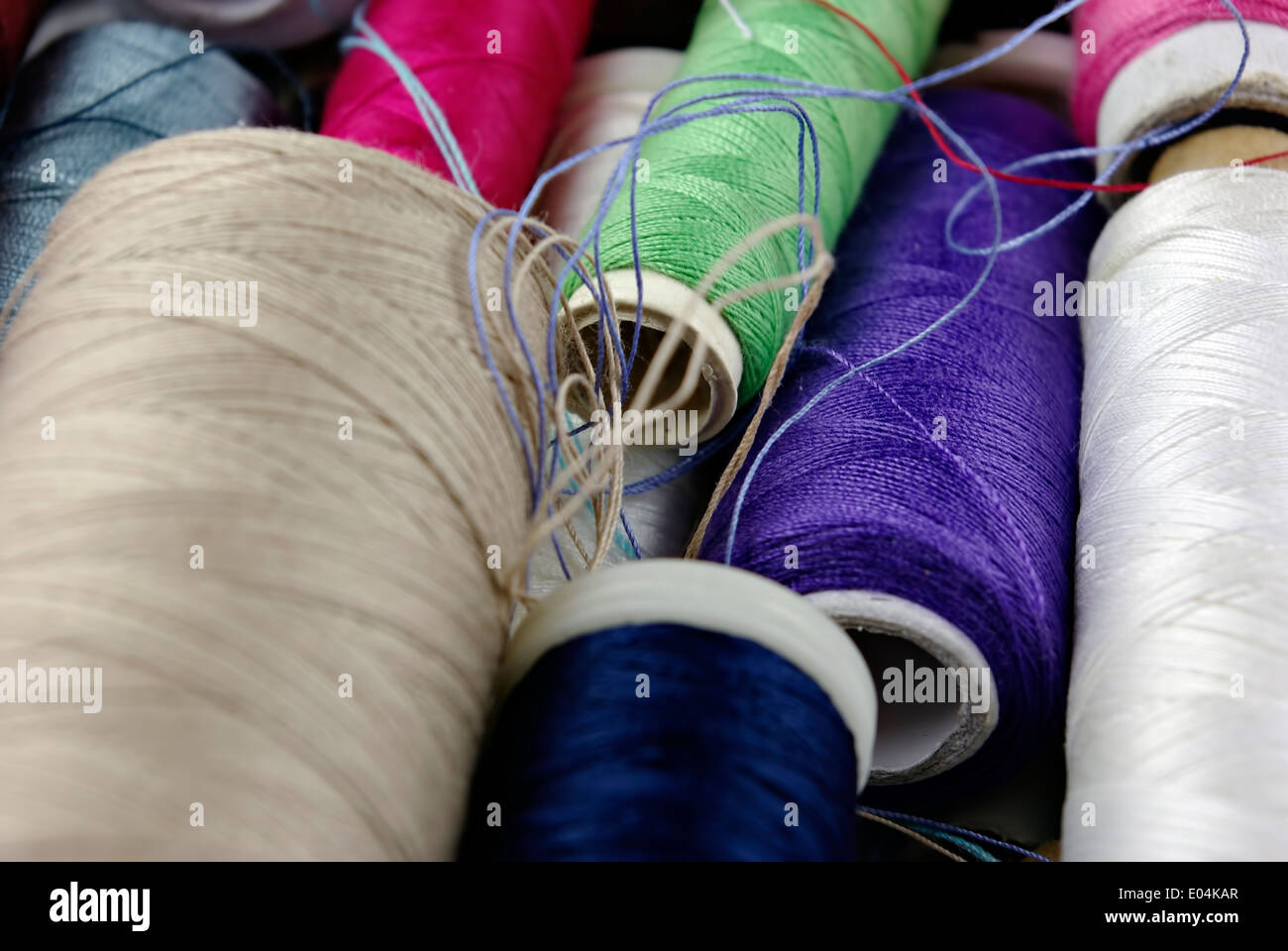Sewing cotton in different colors, packed and unpacked, in plastic box ...