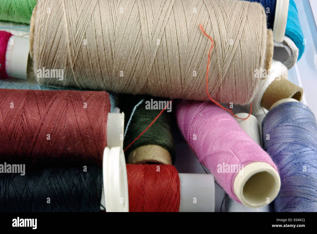 Sewing cotton in different colors, packed and unpacked, in plastic box ...