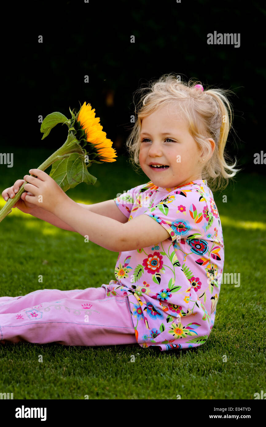 Small child with sunflower in the guards in buzzer, Kleines Kind mit ...