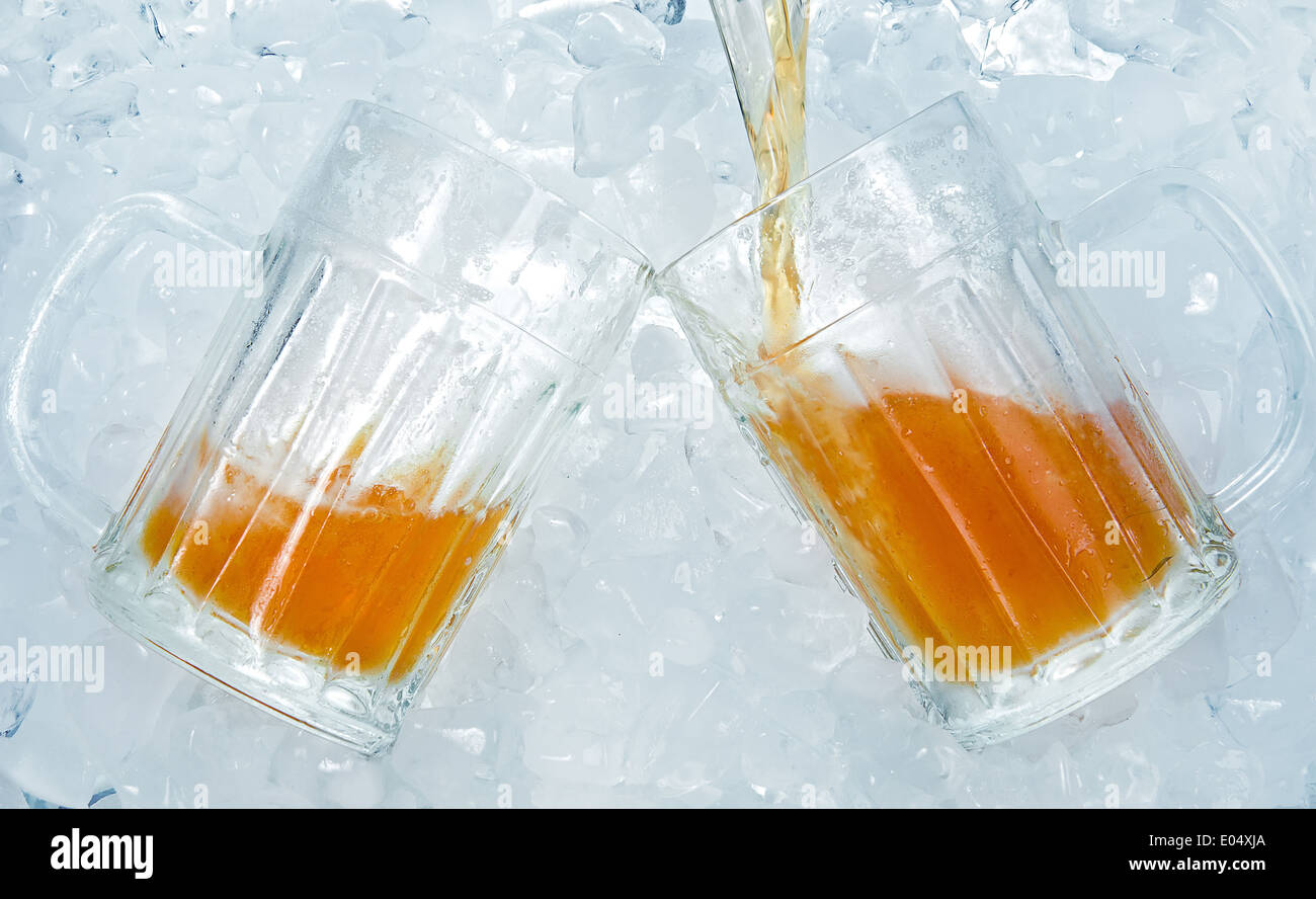 Glass of cold beer lying in the ice Stock Photo - Alamy