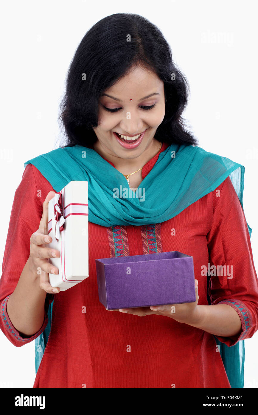 Surprised young woman with gift box against white background Stock ...