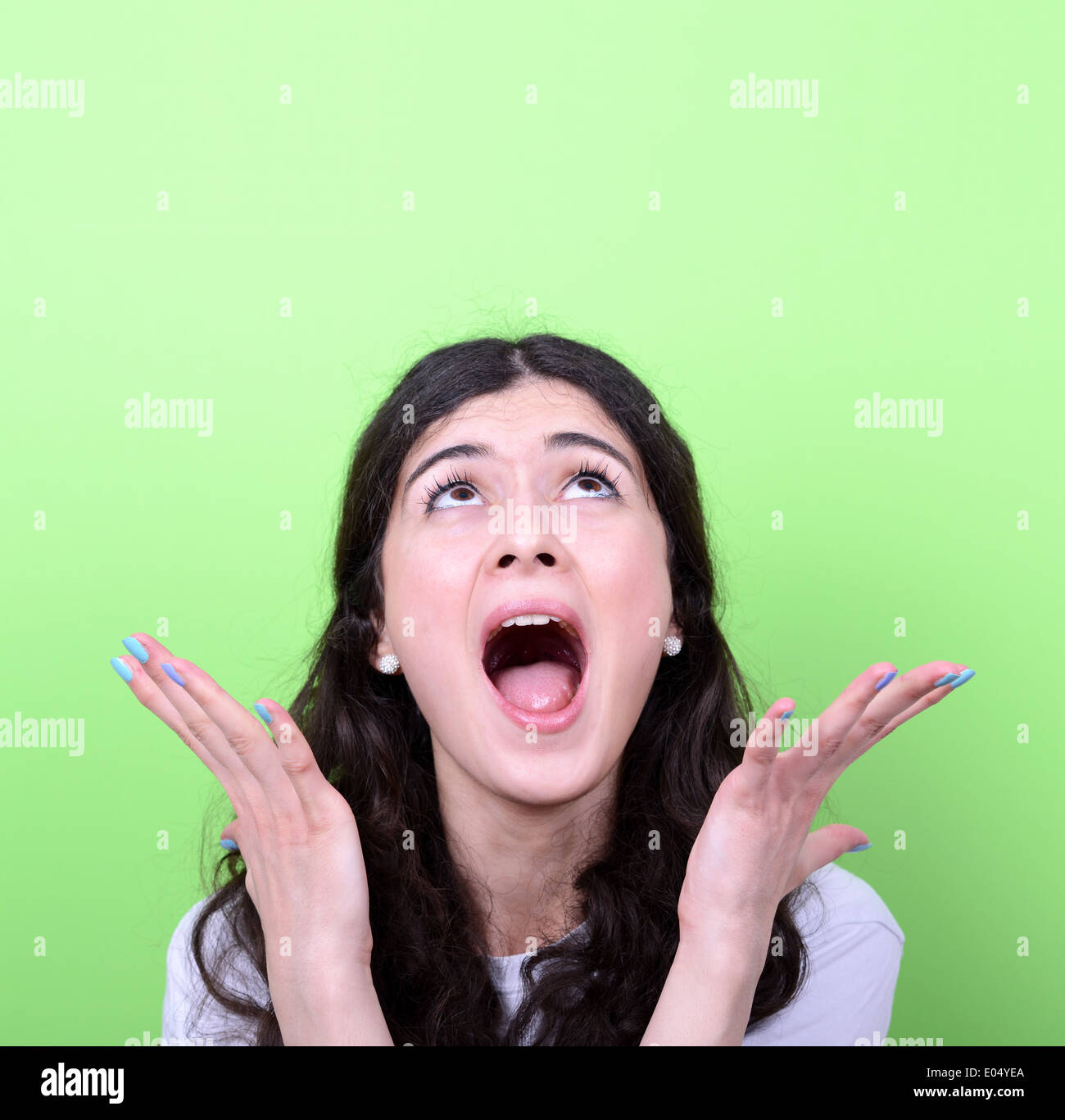 Portrait of beautiful sad girl looking up and begging against green ...