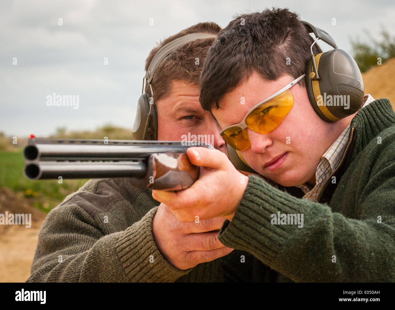Young man with an over and under shot gun at a clay pigeon shooting ...