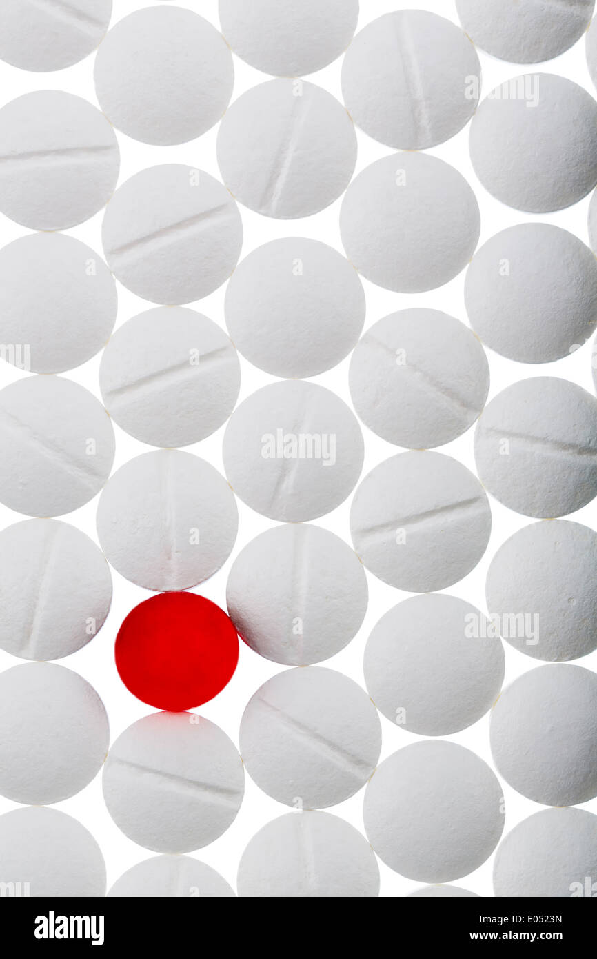 White tablets in the contrast with a red tablet, symbolic photo for ...
