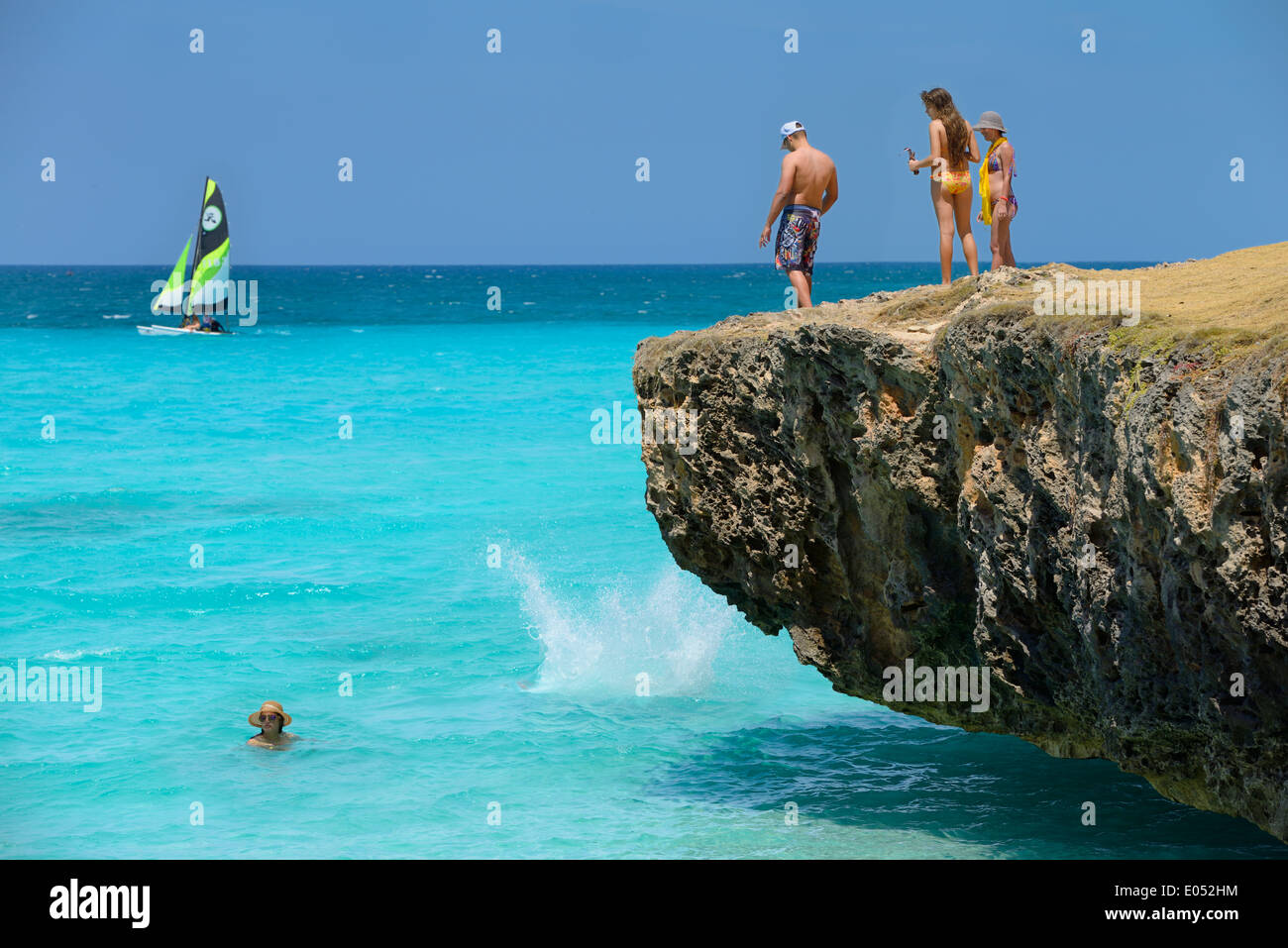 Tourists jumping off Lava rock into turquoise water at Varadero ...