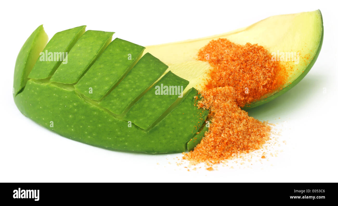 Sliced green mango with chili powder and salt over white background ...