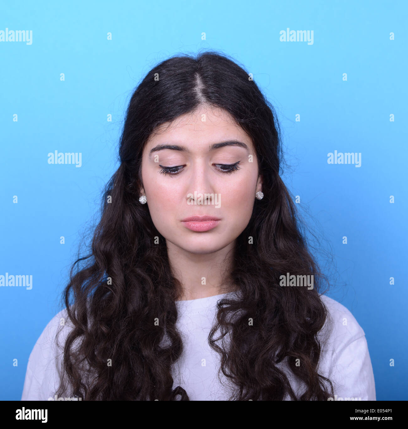 Portrait of sad girl against blue background Stock Photo - Alamy
