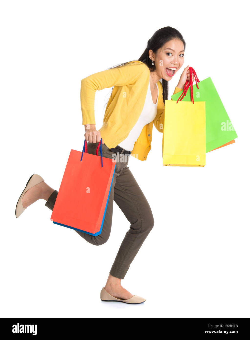 Full body Asian woman running with shopping bags, isolated on white ...