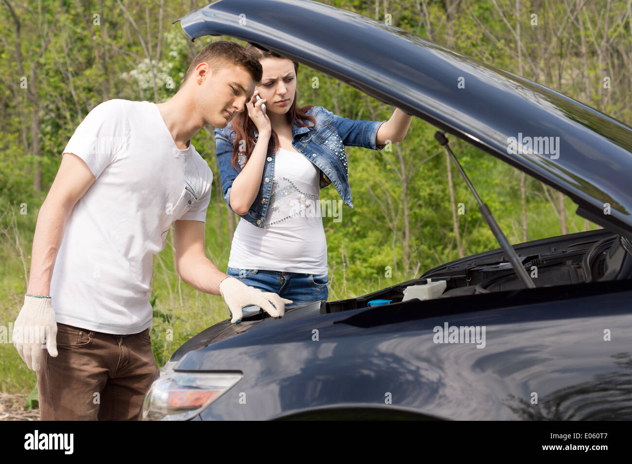 Young mechanic looking at a car engine Stock Photo - Alamy