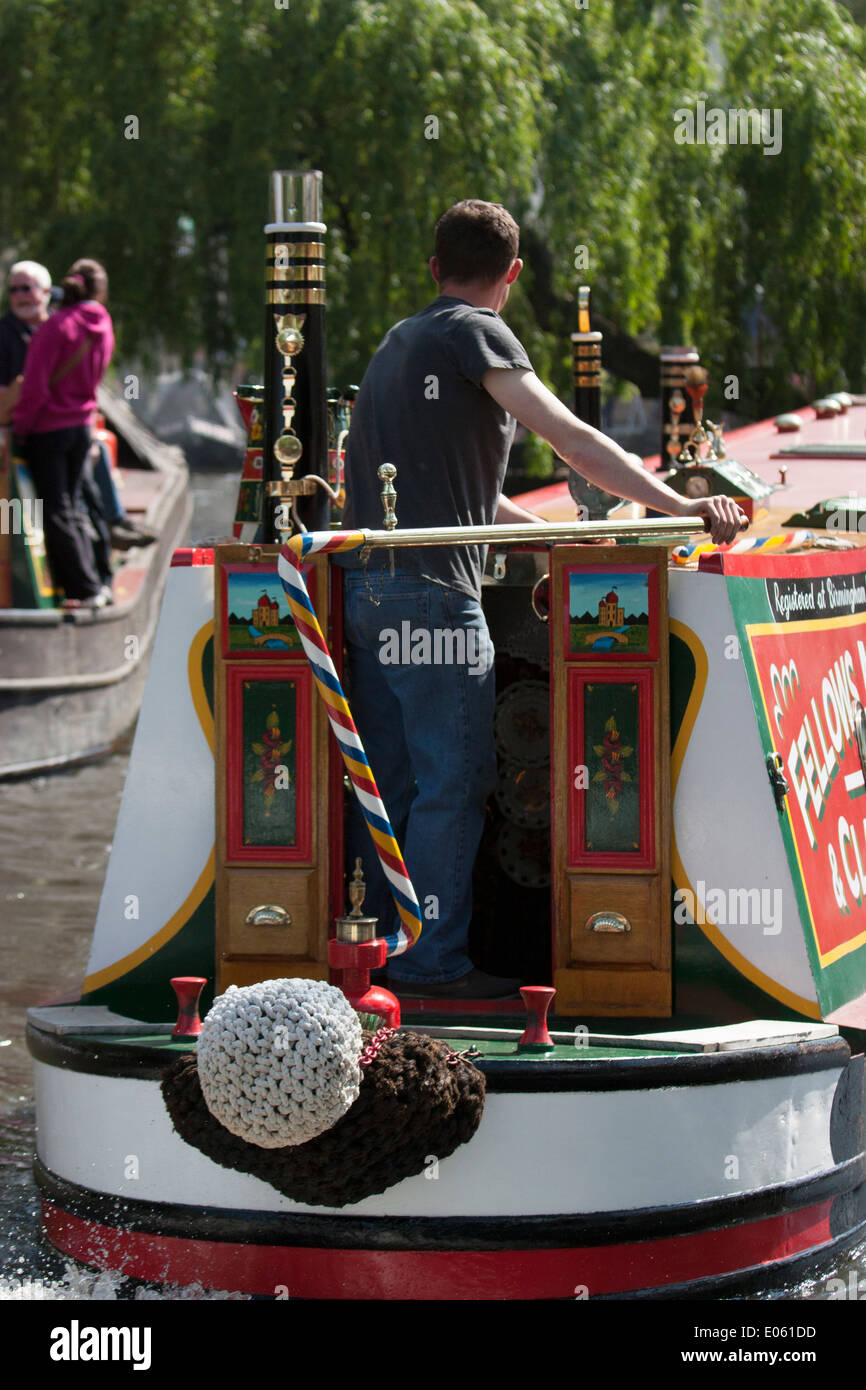 Canal boat owner steering a narrowboat through Little Venice, London ...