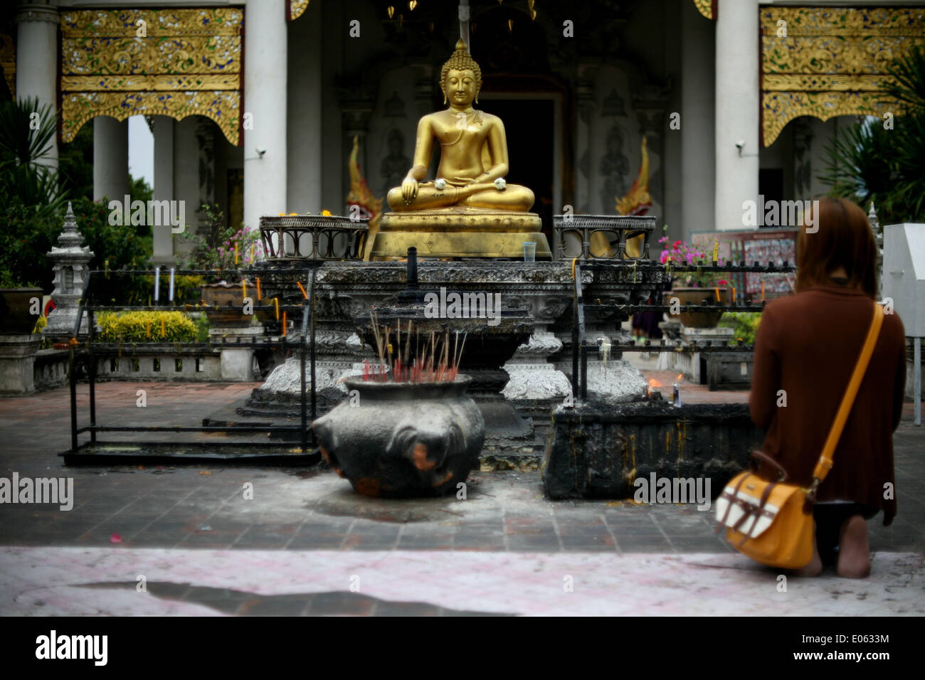 Chiang Mai, Thailand. 3rd May, 2014. A lady praying in front of a Wat ...
