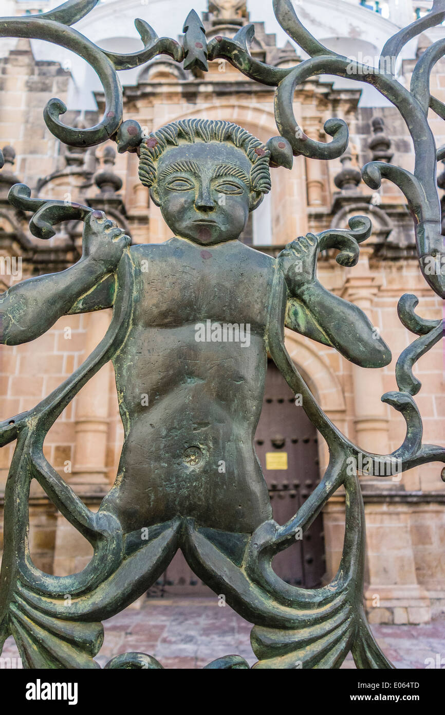 A cast iron gate with a greenish patina and a figure of a man without ...