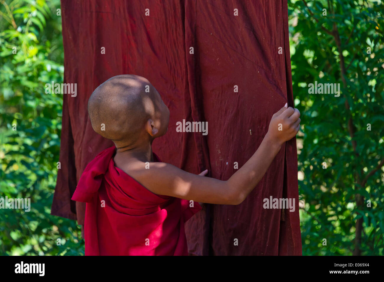 Monk hanging laundry on cloth line iin the monastery, Bagan, Myanmar ...