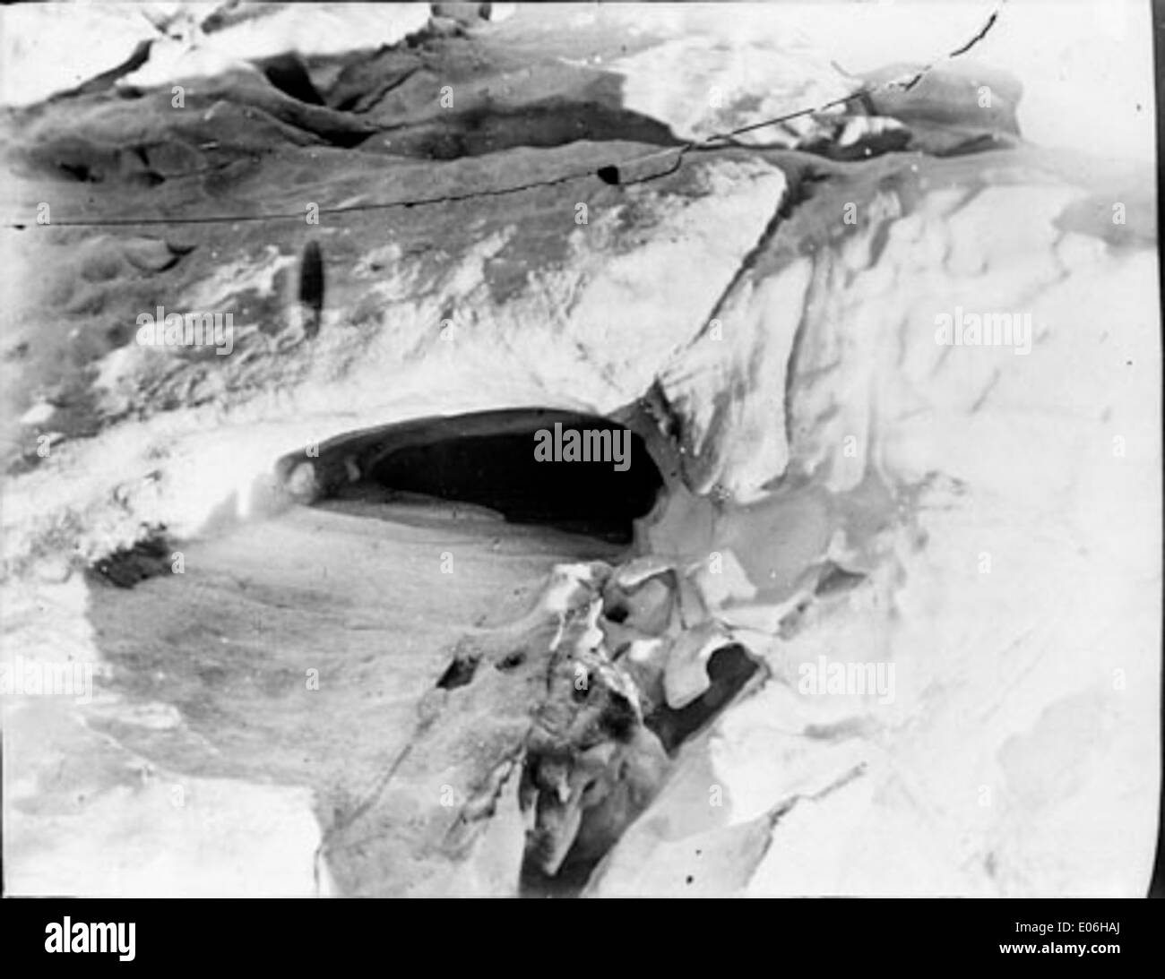 A photograph of a natural ice tunnel in a Swiss glacier, showcasing the ...