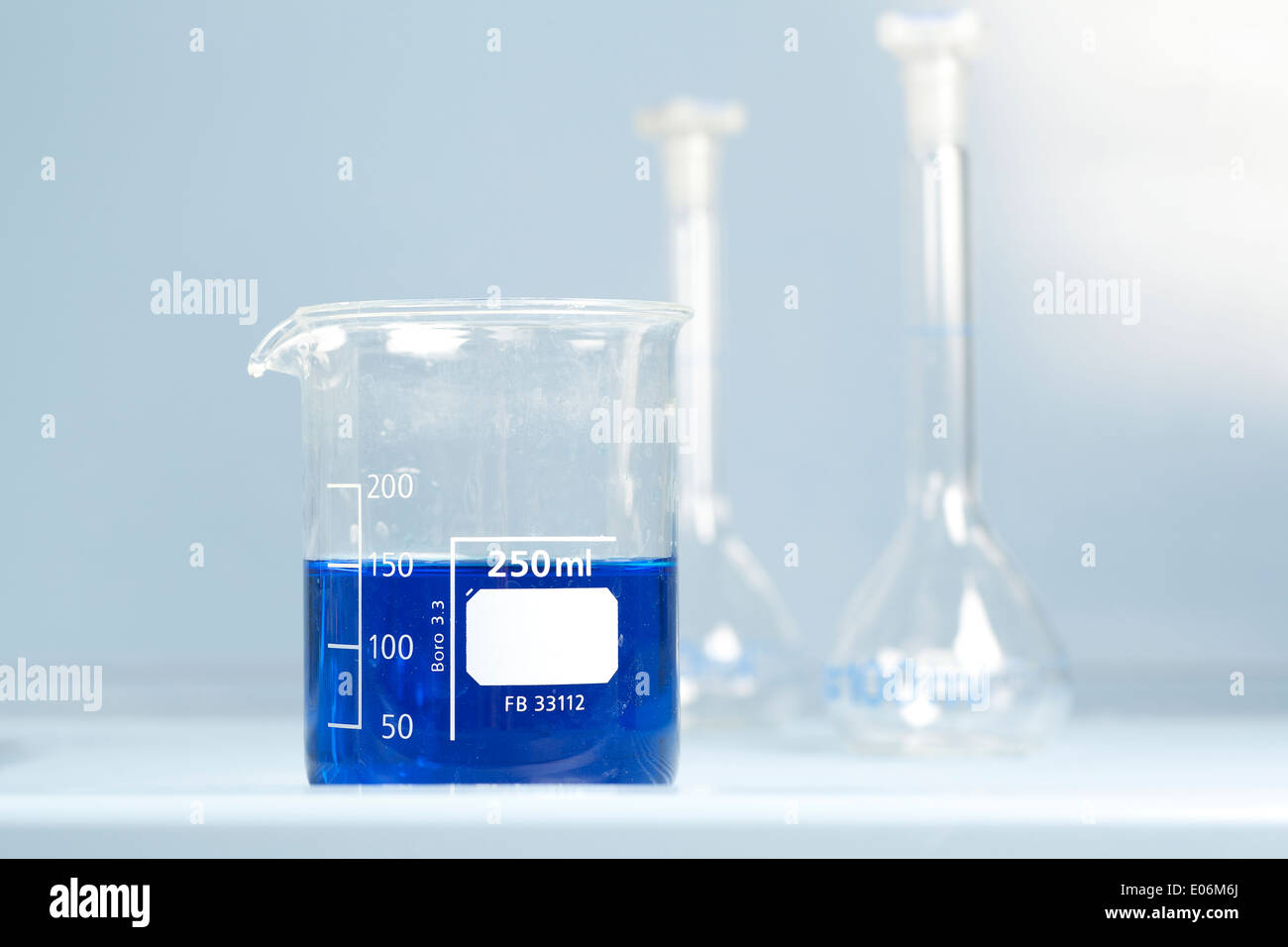 Glass beaker in laboratory filled with blue solutions Stock Photo - Alamy
