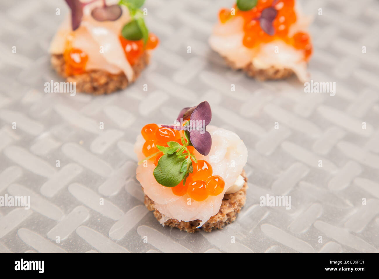Appetizer of Salmon eggs, fish, and green herbs canapes Stock Photo - Alamy