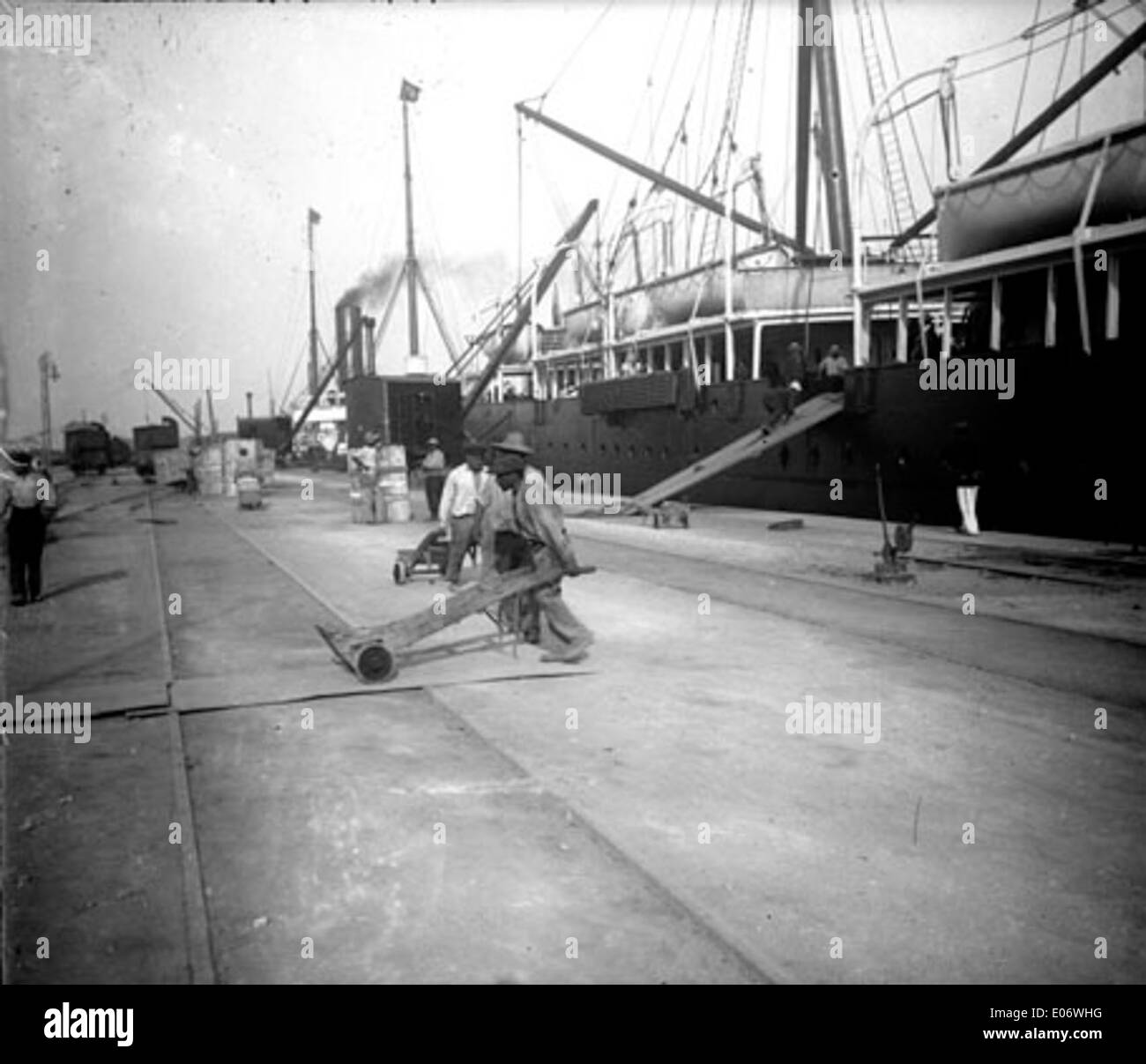 A photograph of dock work at a port, showing workers engaged in ...